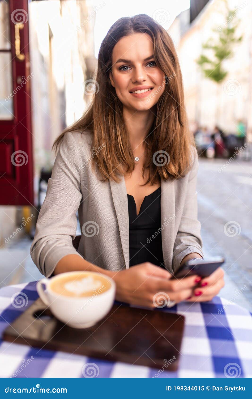 Young Woman Typing Text Message on Smart Phone in a Cafe. Young Woman ...