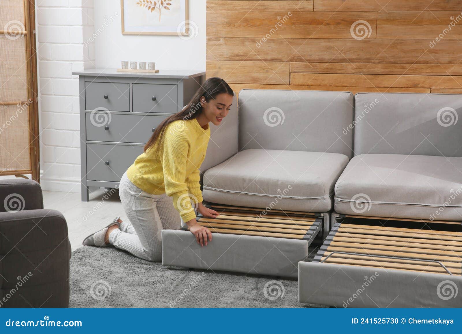 Young Woman Unfolding Sofa into a Bed in Room. Modern Interior Stock ...
