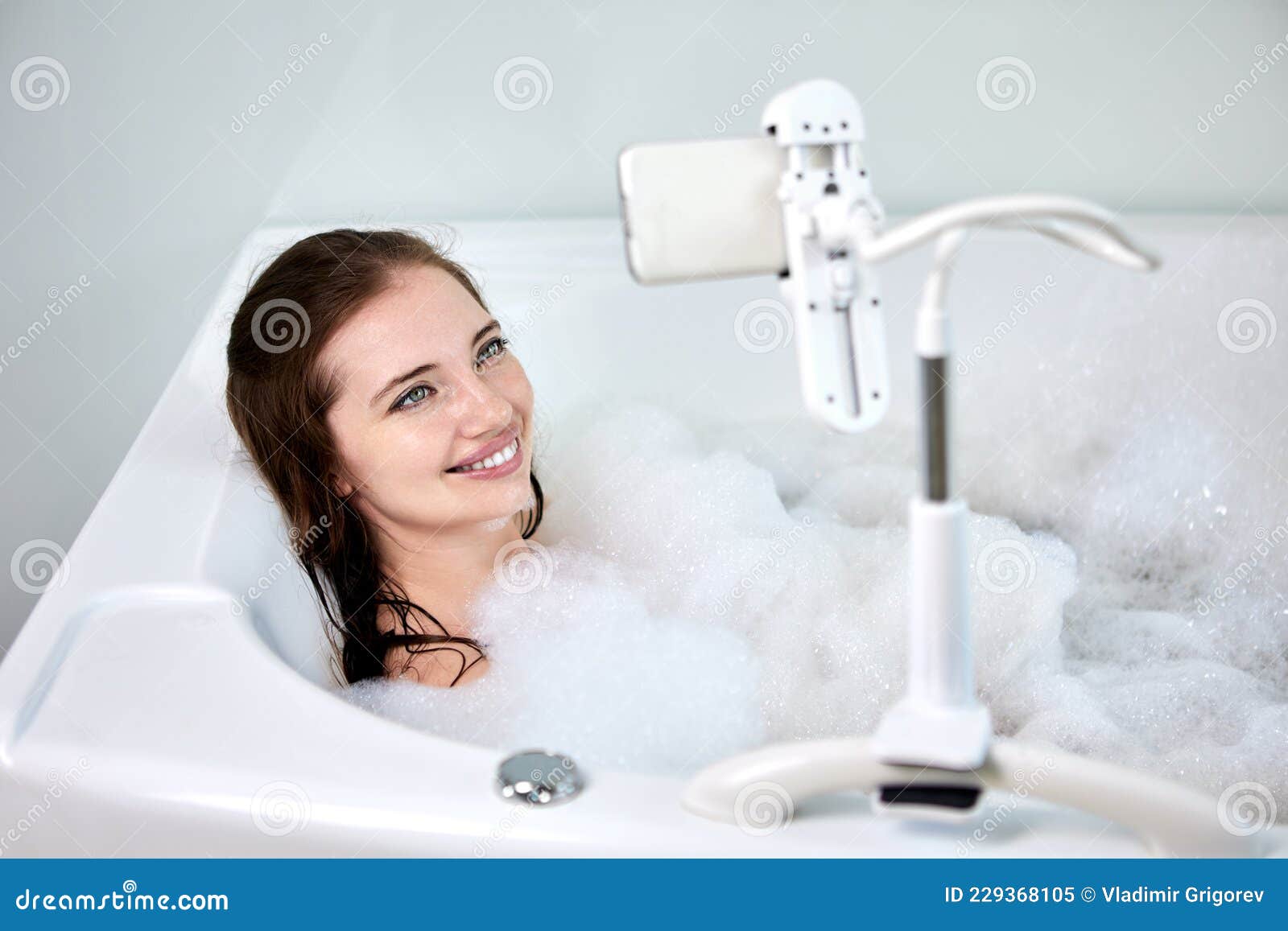 Mounting Hands Free Smartphone Holder On Bathtub In Bathroom Young