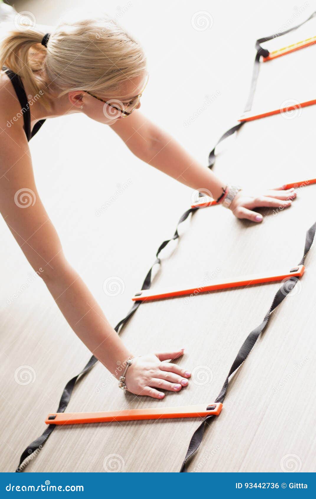 Woman using agility ladder stock photo. Image of exercising - 93442736