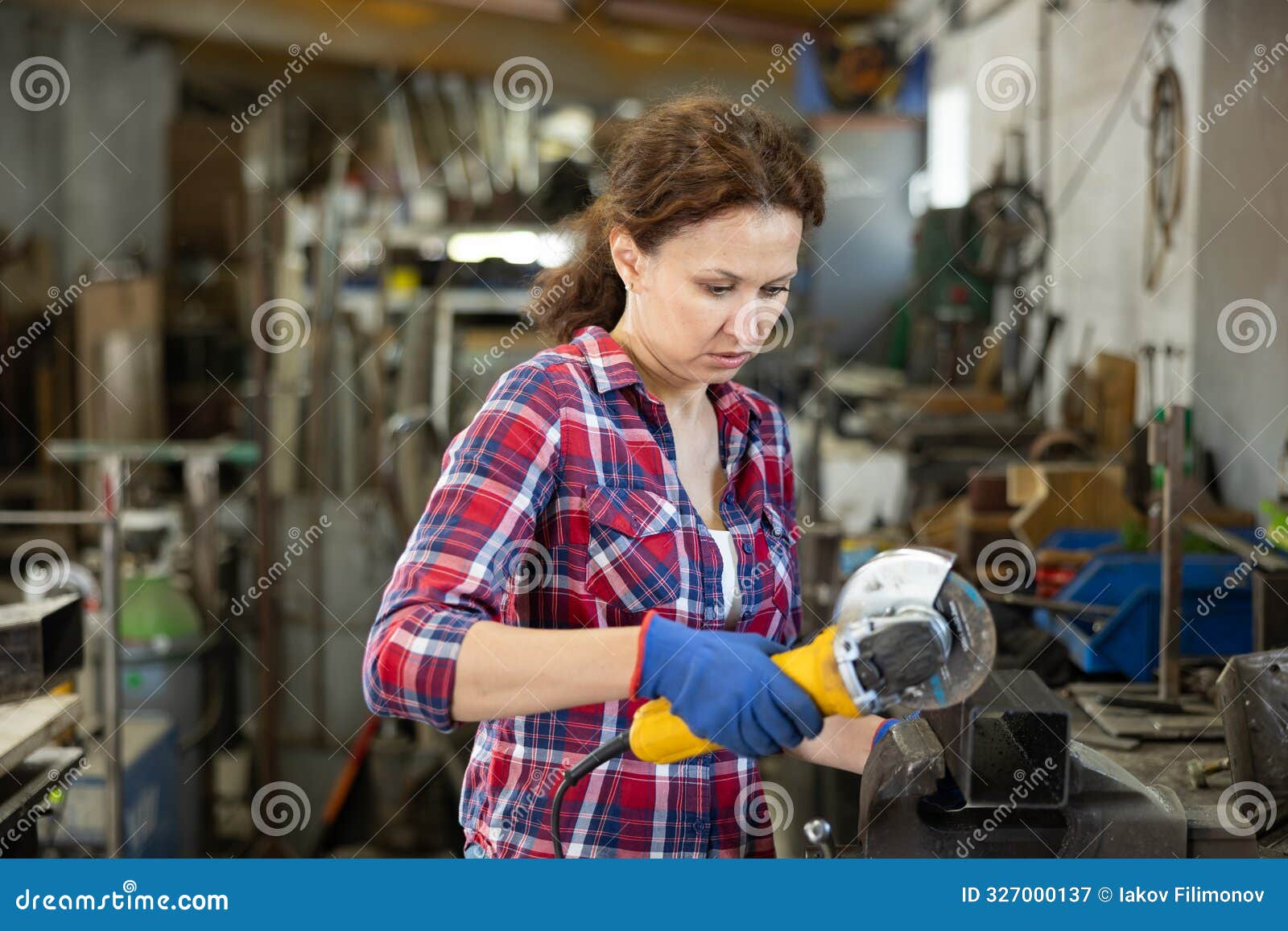 Woman Using Angle Grinder To Cut Metal Profile in Metal Fabrication ...