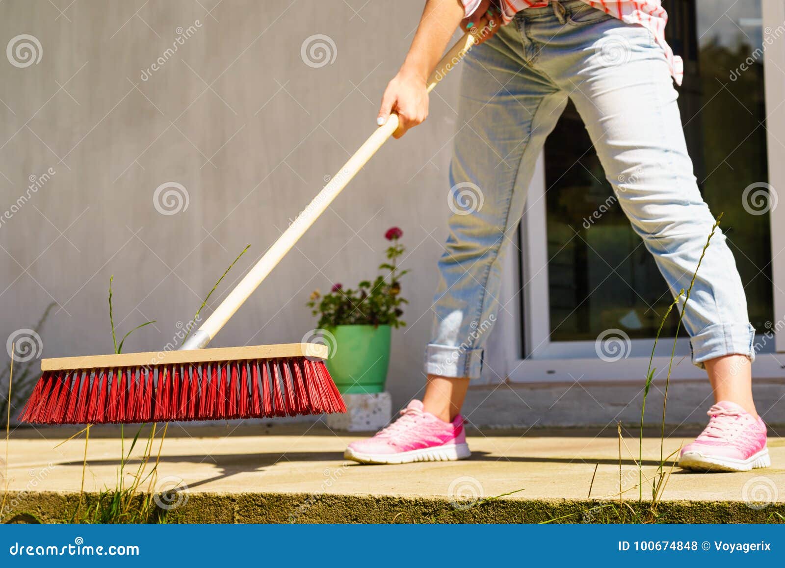 Woman Using Broom To Clean Up Backyard Patio Stock Foto - Image of ...