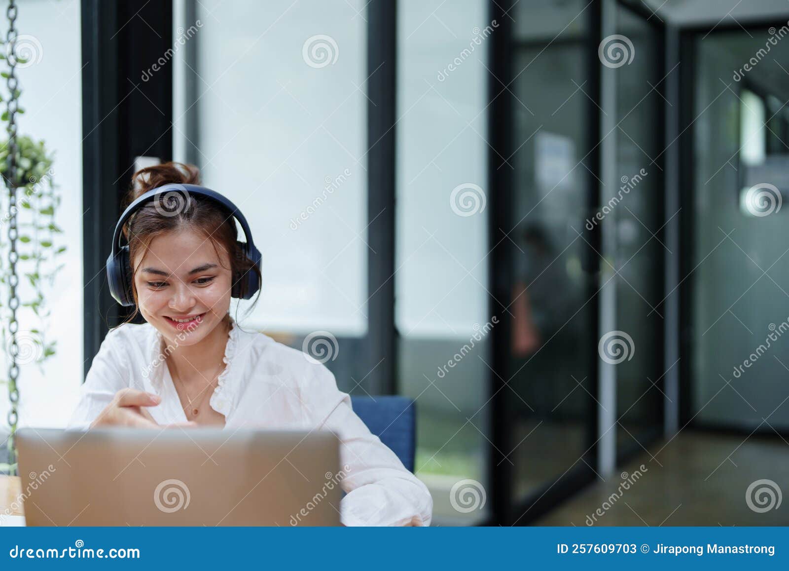 Woman Using a Computer and Earphone during a Video Conference Stock ...
