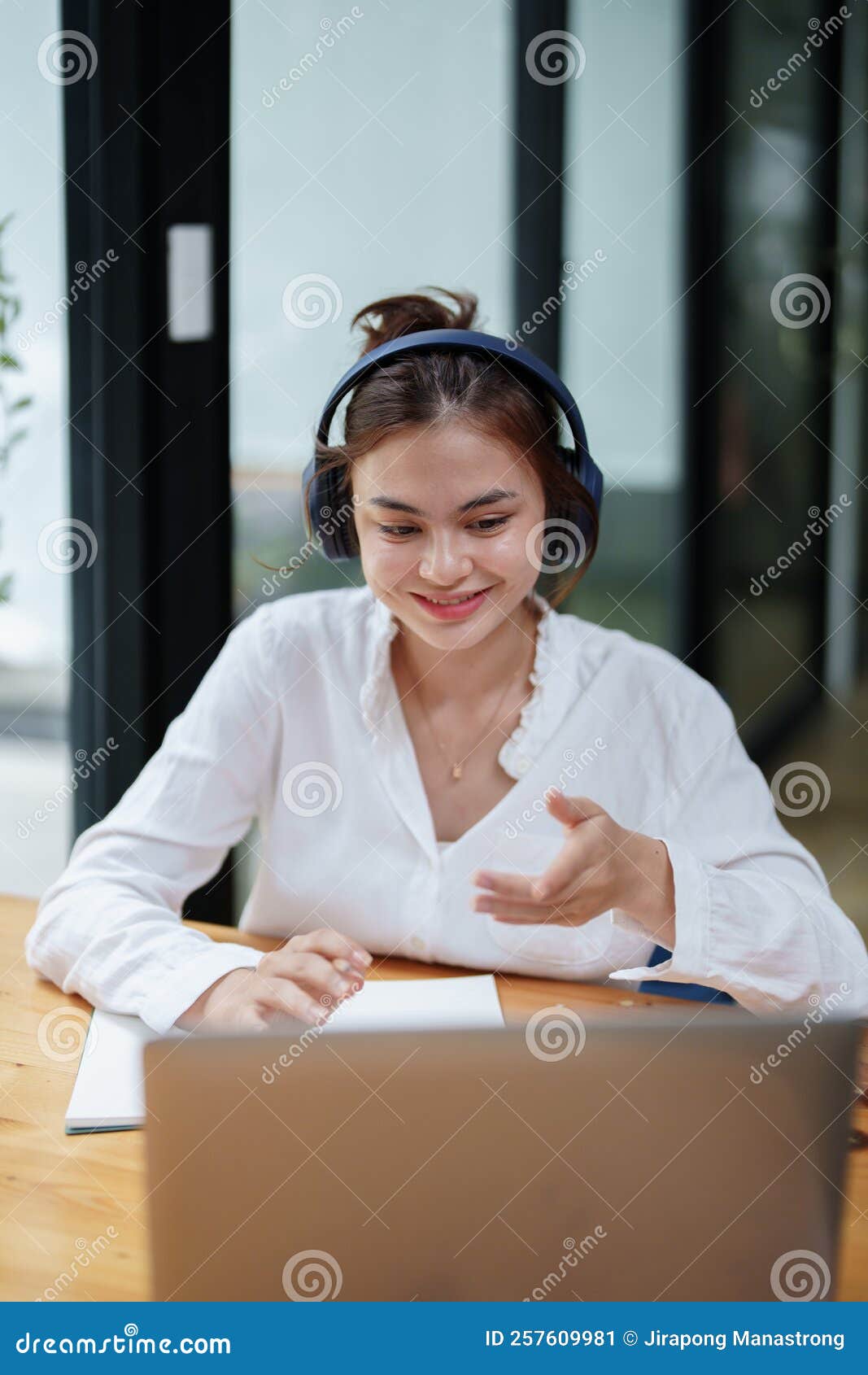 Woman Using a Computer and Earphone during a Video Conference Stock ...