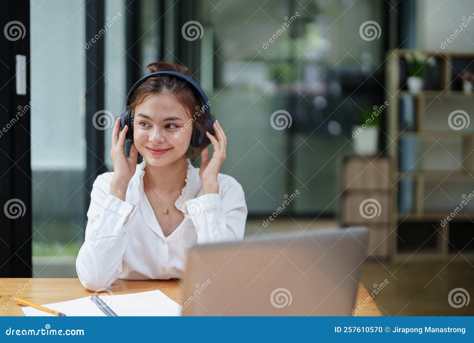 Woman Using a Computer and Earphone during a Video Conference Stock ...