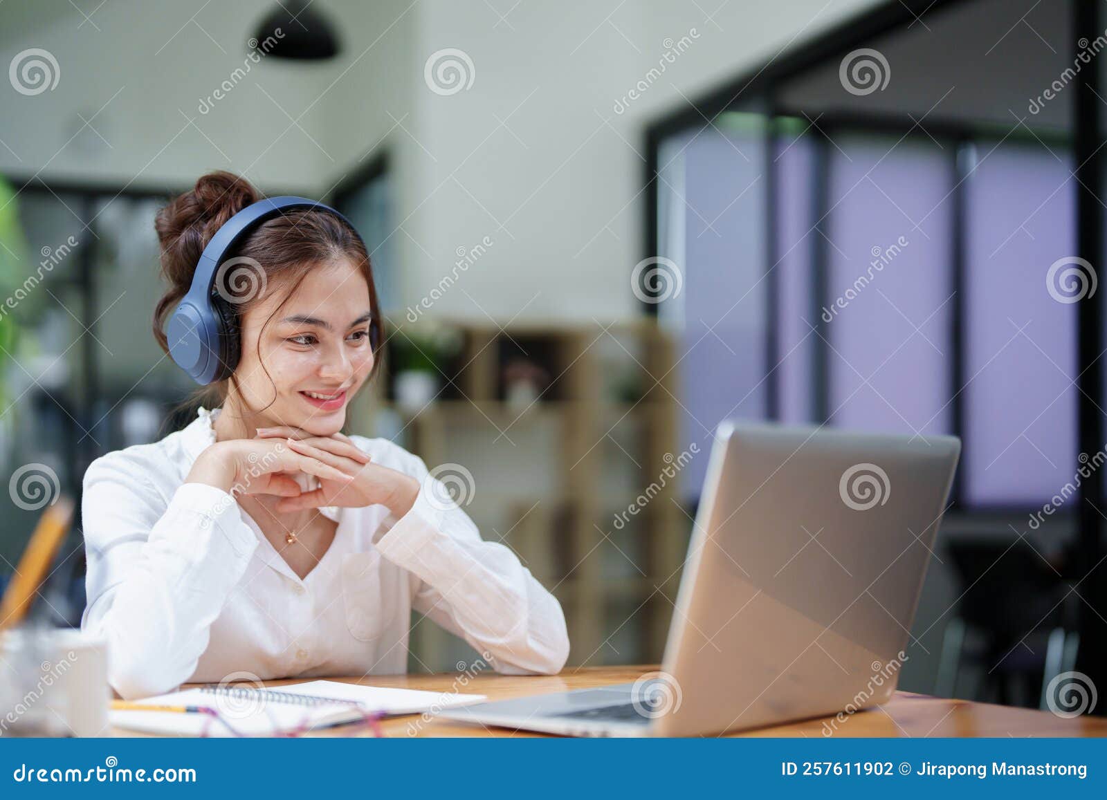 Woman Using a Computer and Earphone during a Video Conference Stock ...