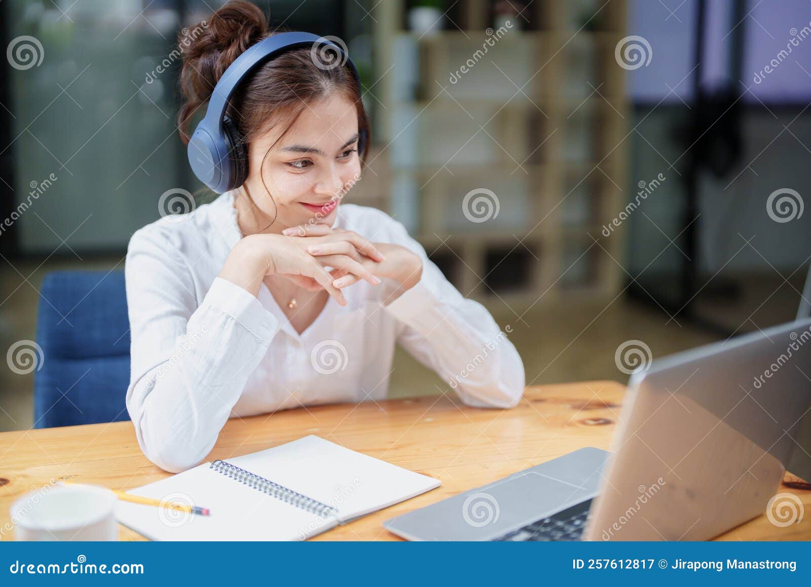 Woman Using a Computer and Earphone during a Video Conference Stock ...