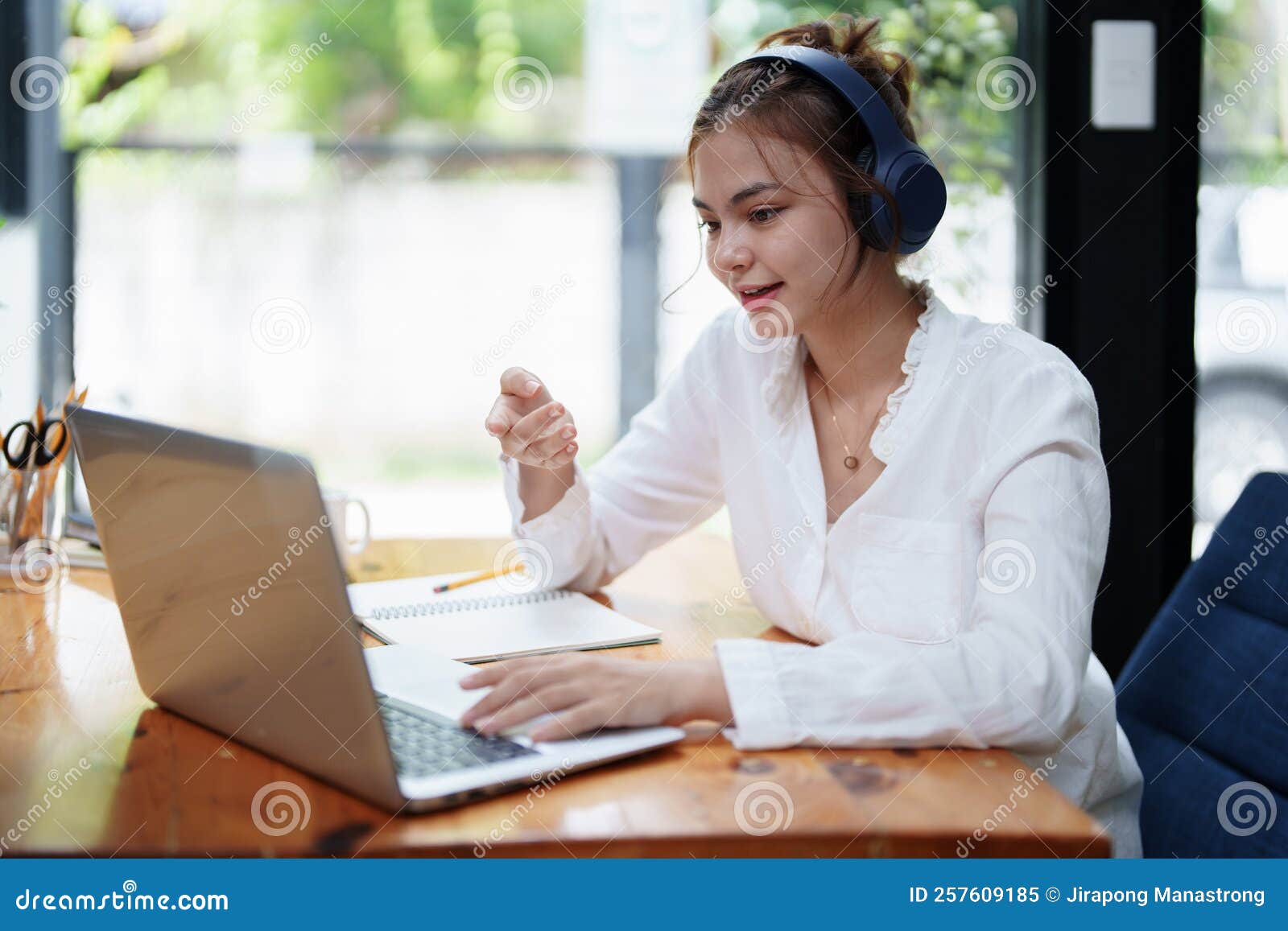 Woman Using a Computer and Earphone during a Video Conference Stock ...