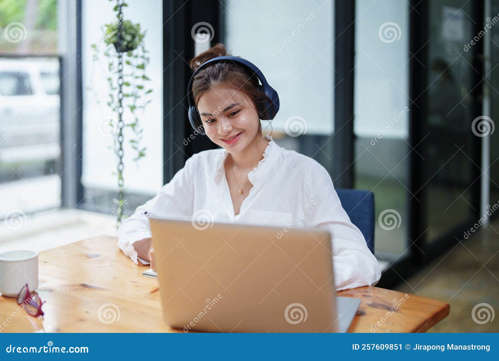 Woman Using a Computer and Earphone during a Video Conference Stock ...