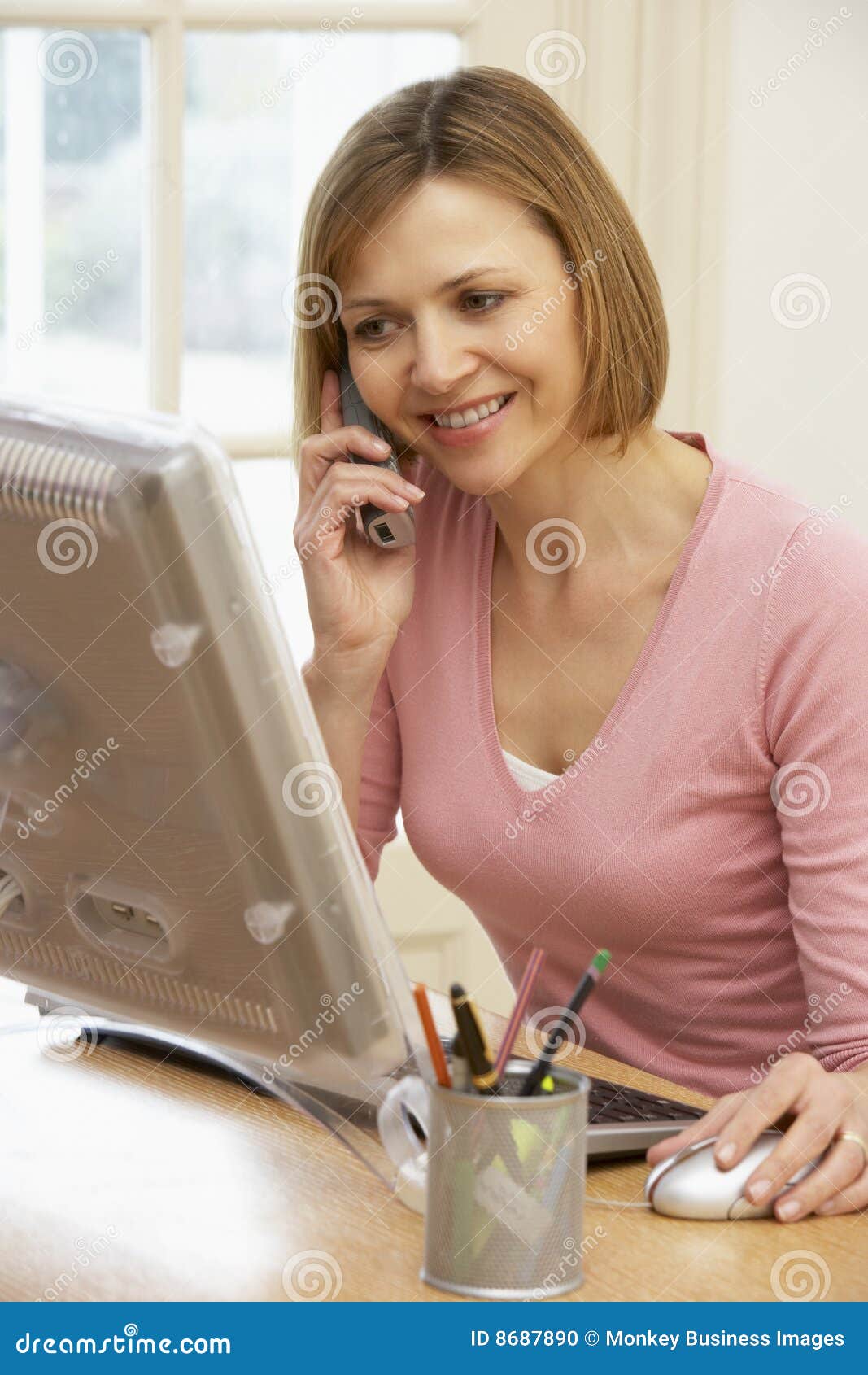 Woman Using Computer and Talking on Phone Stock Photo - Image of person ...
