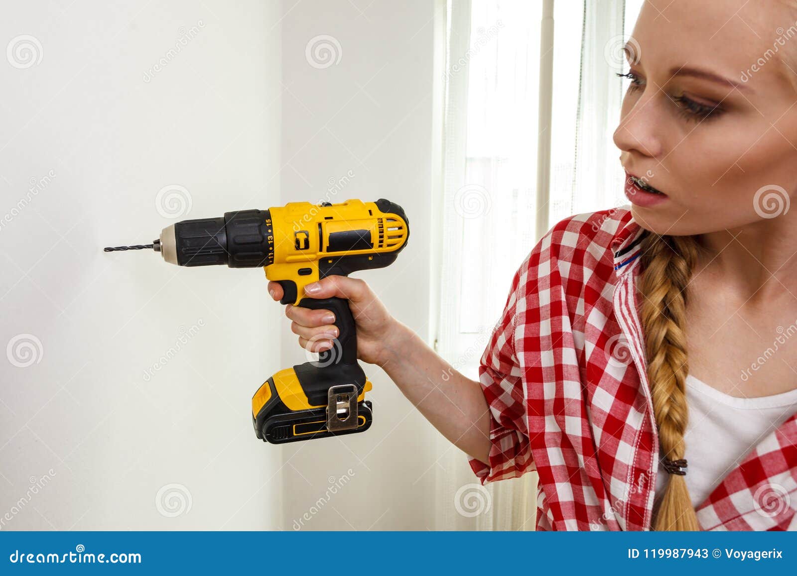 Woman using drill on wall stock image. Image of equipment - 119987943