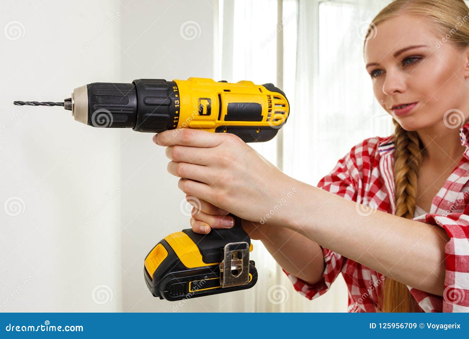 Woman using drill on wall stock image. Image of constructor - 125956709