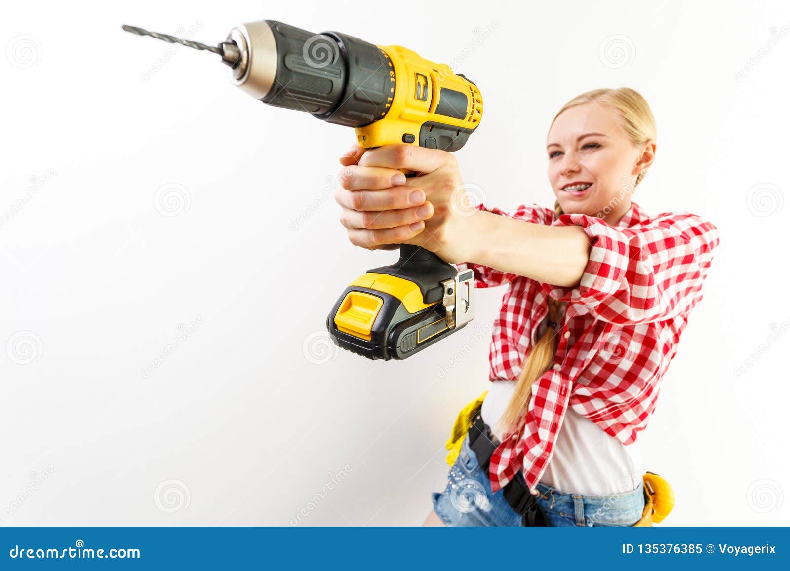 Woman using drill on wall stock image. Image of constructor - 135376385