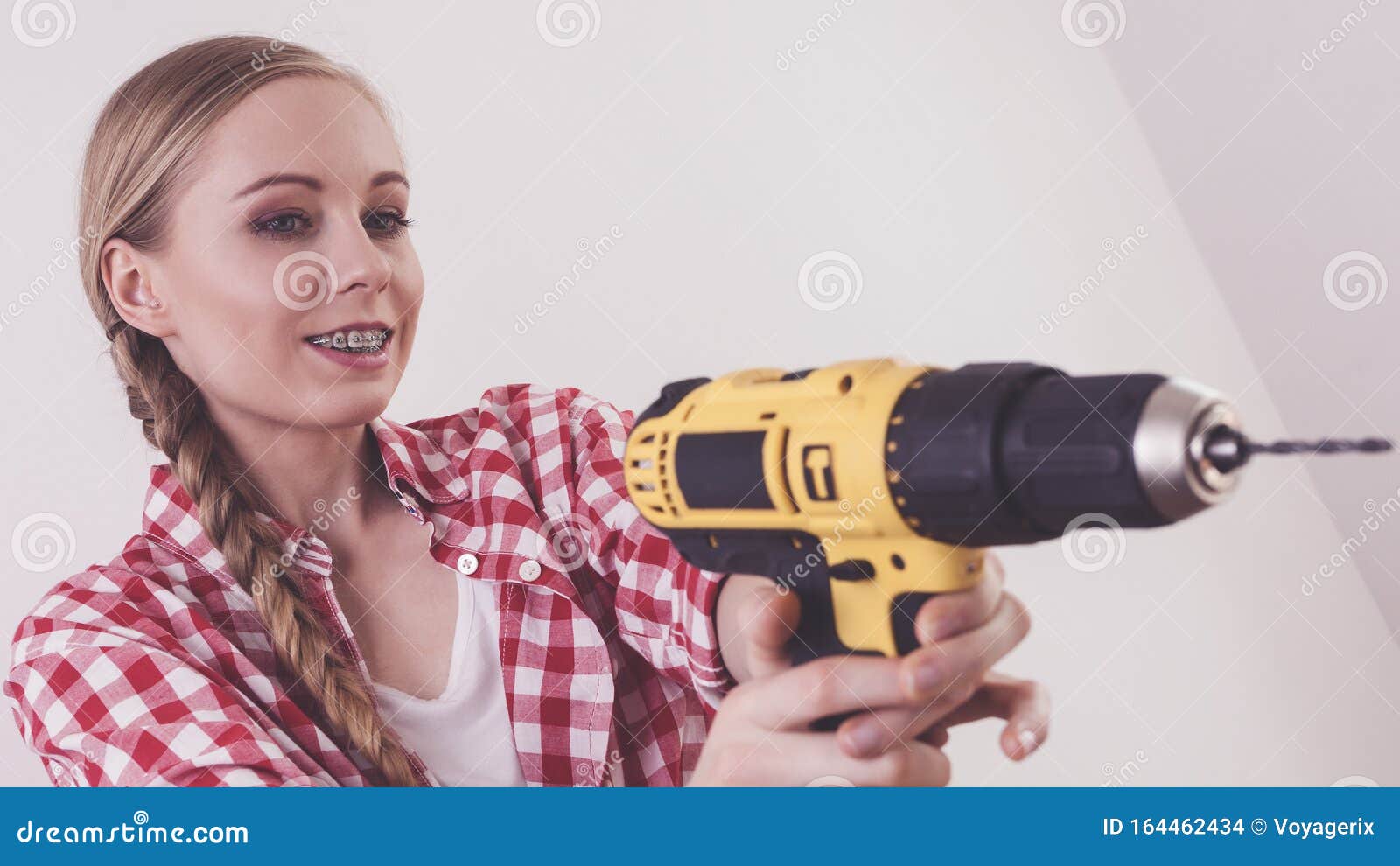 Woman using drill on wall stock photo. Image of constructor - 164462434
