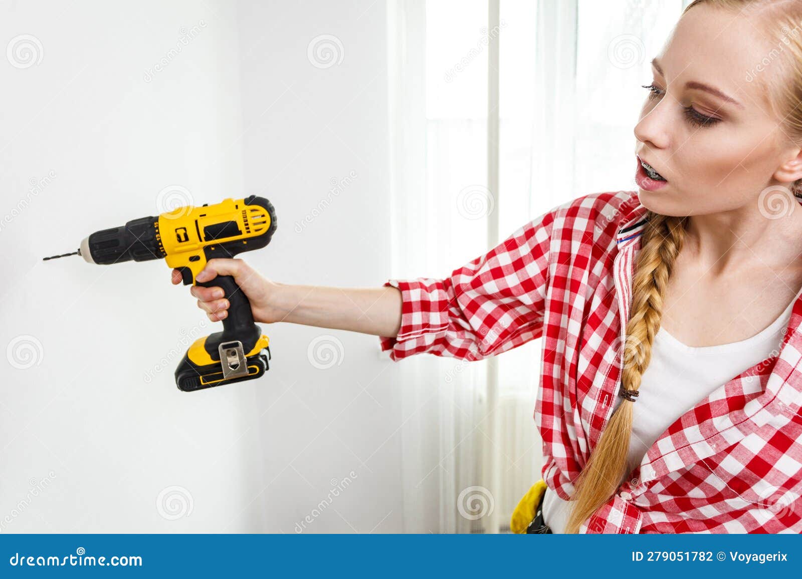 Woman using drill on wall stock photo. Image of work - 279051782