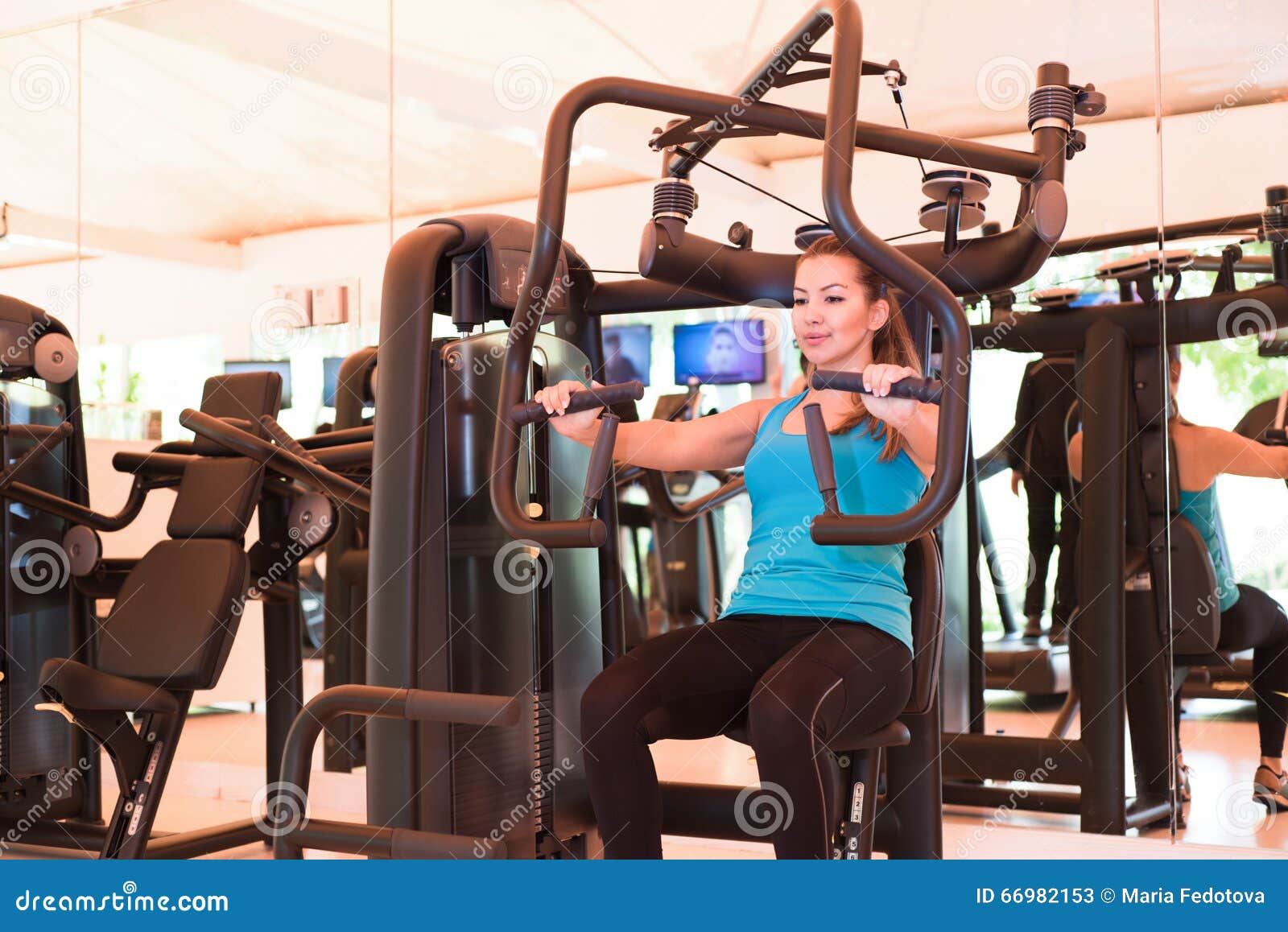 Woman Using a Gym Machine stock image. Image of female - 66982153