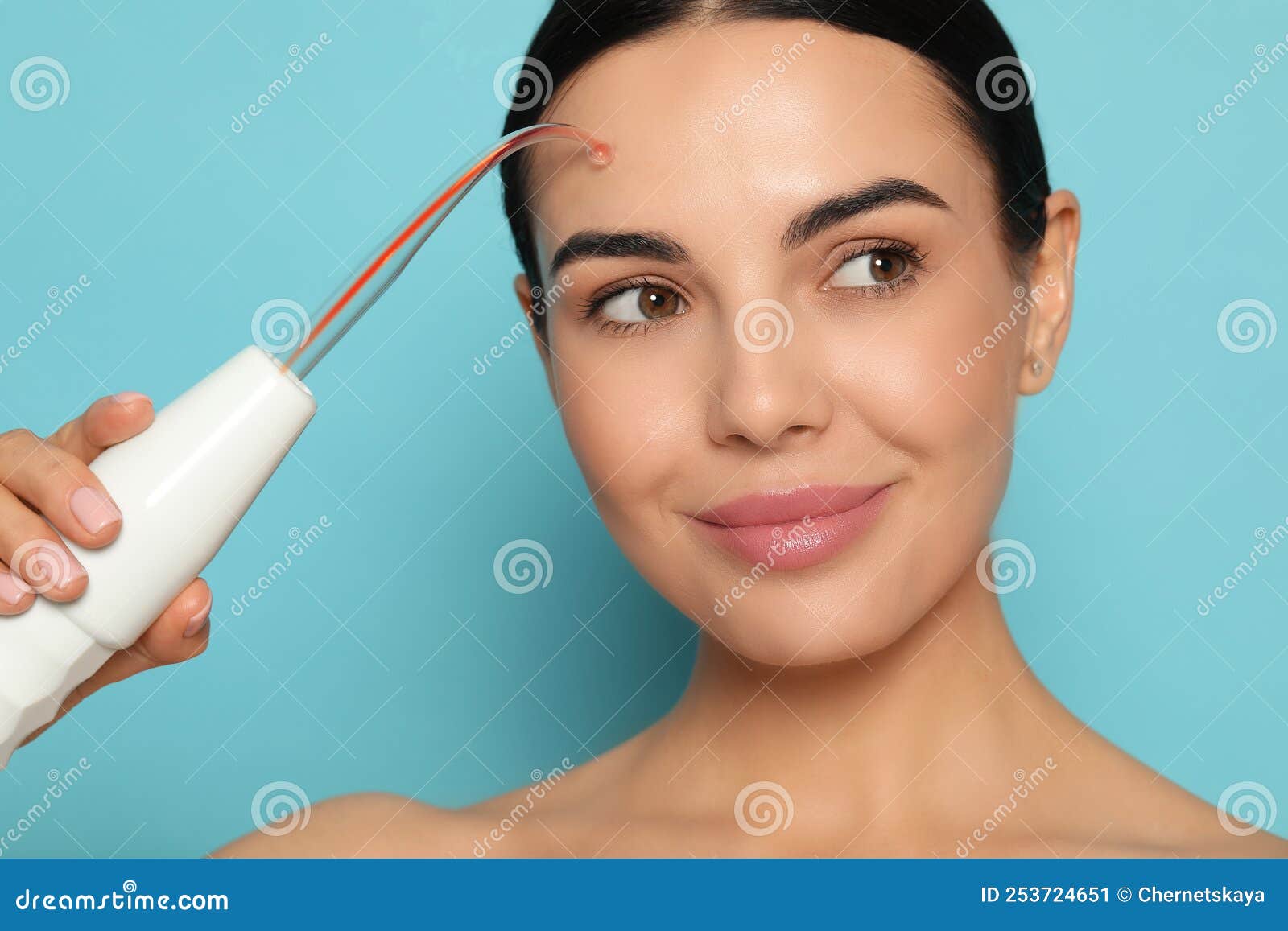 Woman Using High Frequency Darsonval Device on Light Blue Background ...