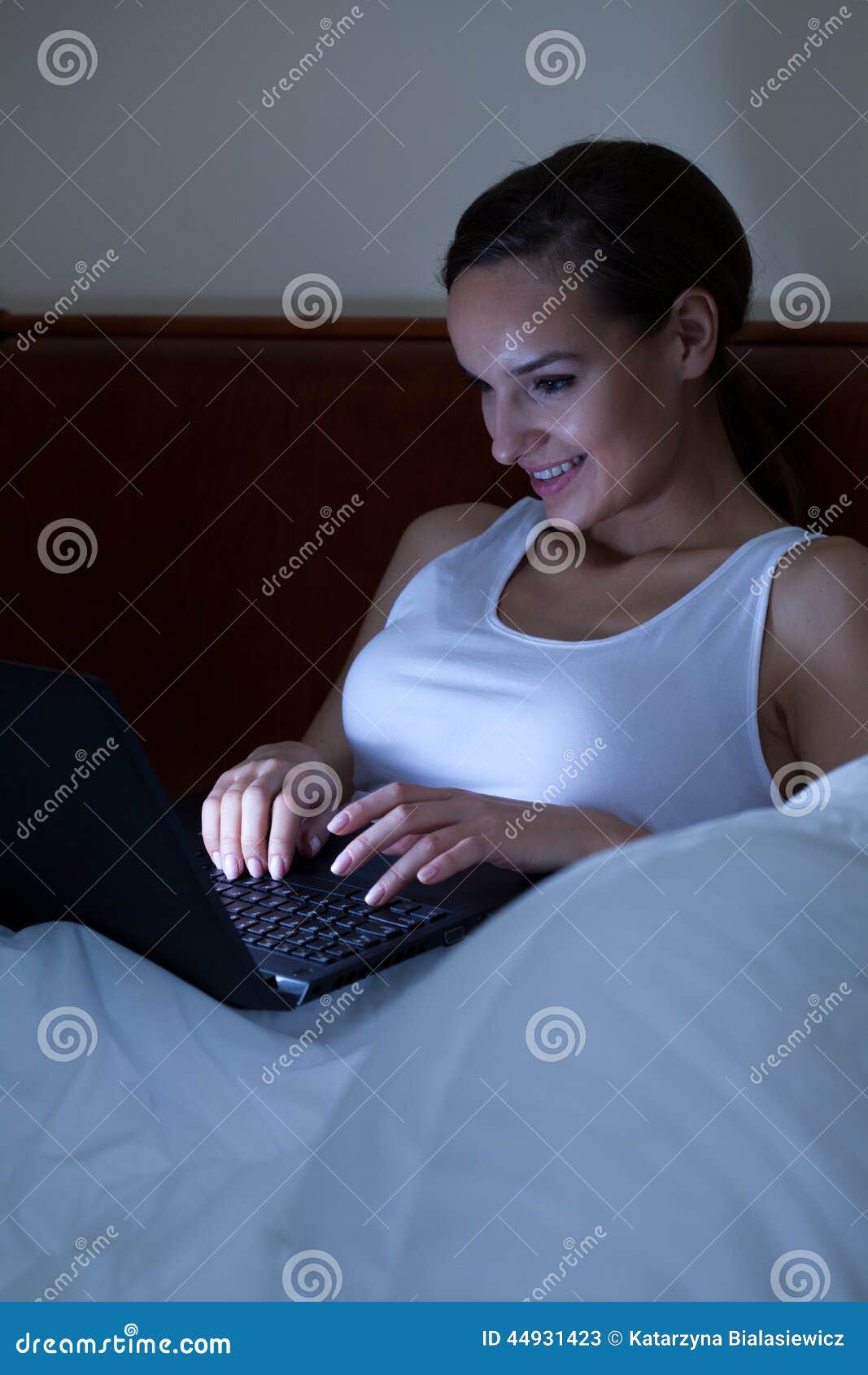 Woman using laptop in bed stock image. Image of addict - 44931423