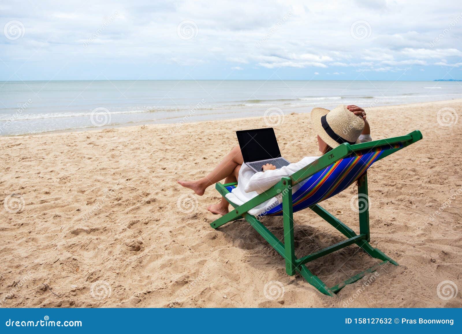 A Woman Using Laptop Computer while Lying Down on a Beach Chair Stock ...