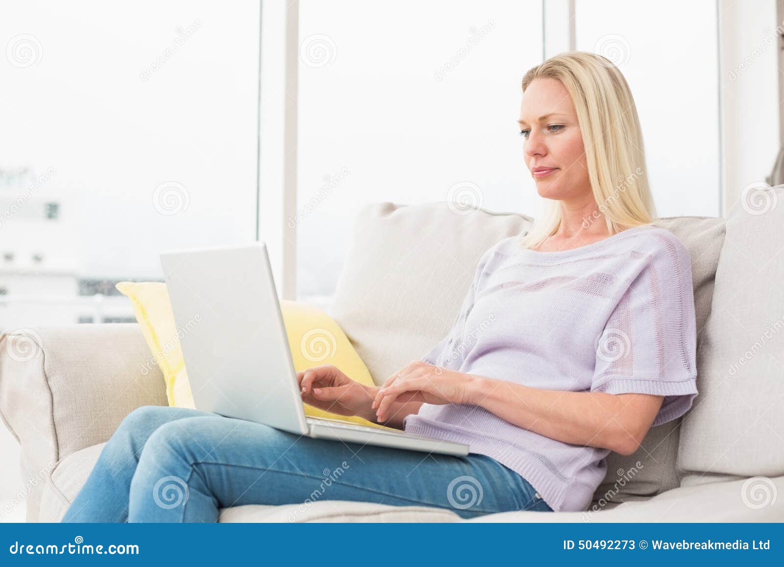 Woman using laptop on sofa stock image. Image of lifestyle - 50492273