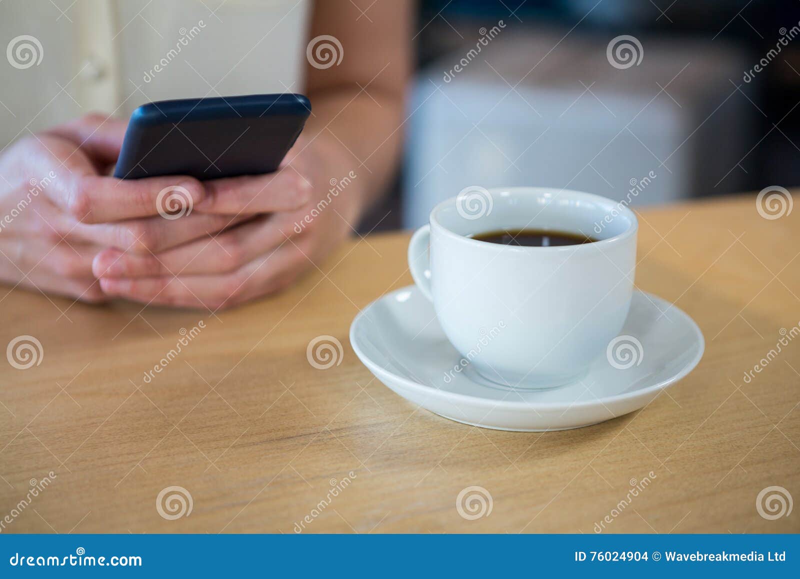Woman Using Mobile Phone and a Coffee Cup on the Table in Coffee Shop ...