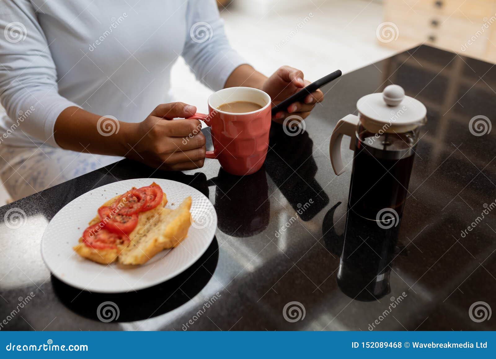 Woman Using Mobile Phone on a Dining Table at Kitchen Stock Photo ...