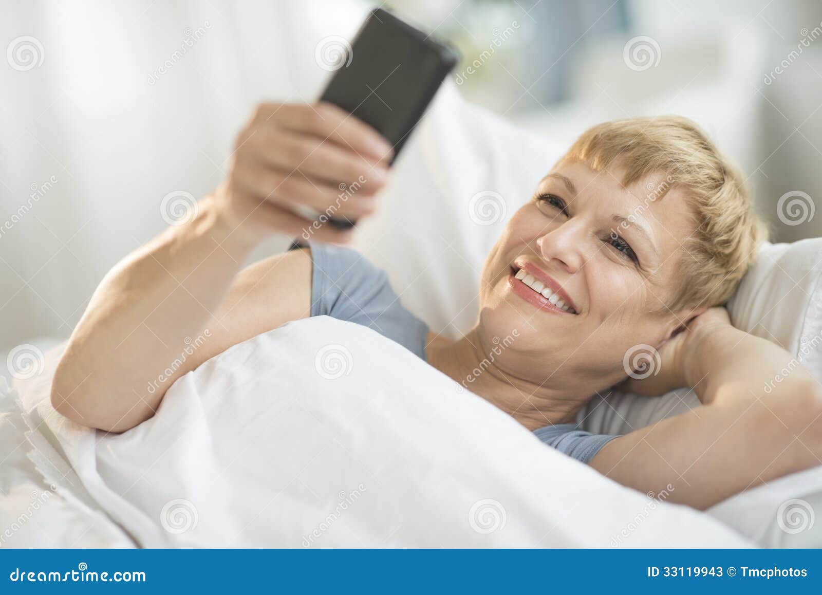Woman Using Mobile Phone while Lying in Bed Stock Image - Image of ...