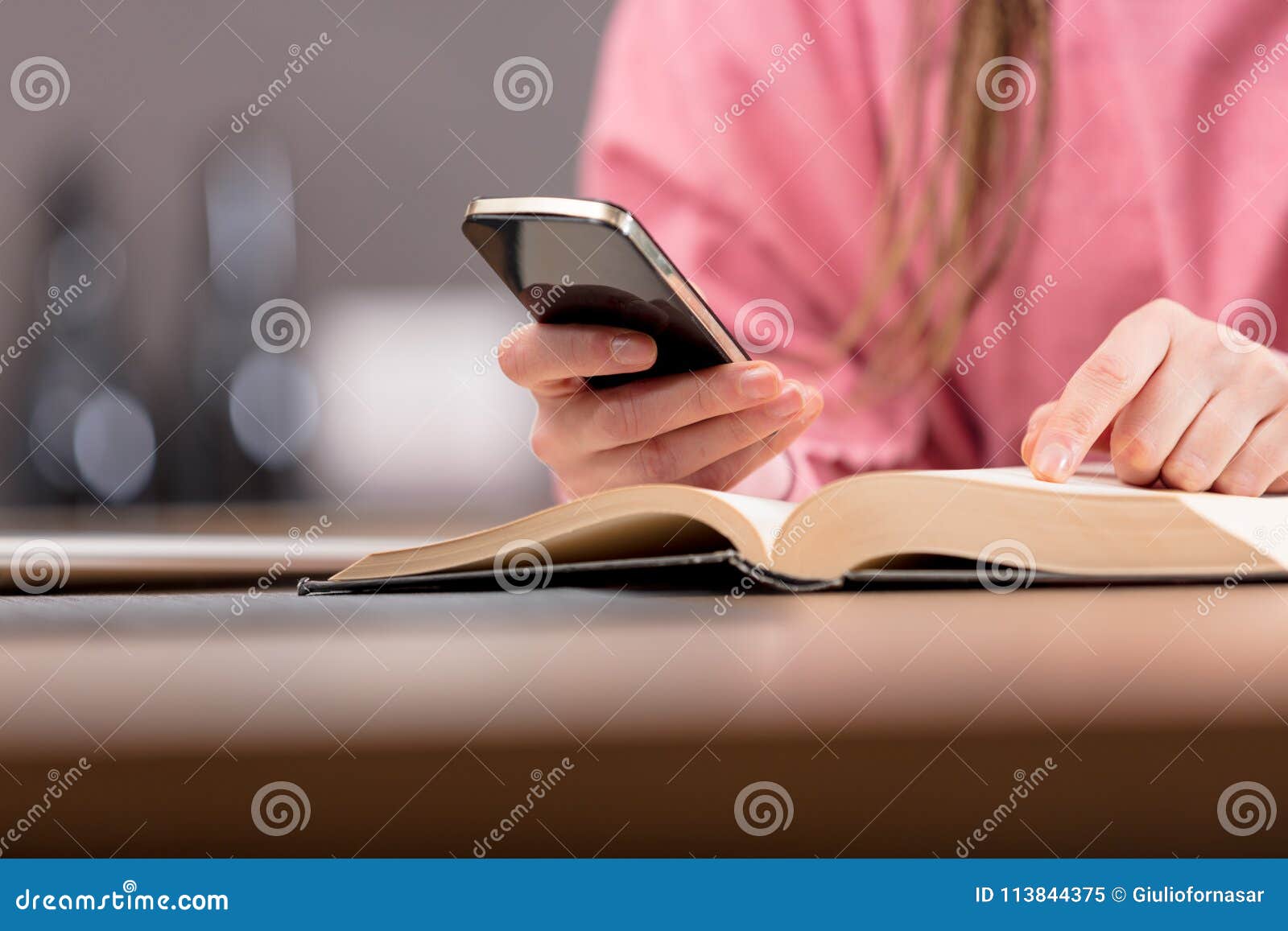 Woman Using Mobile Phone while Reading Book Stock Image - Image of ...