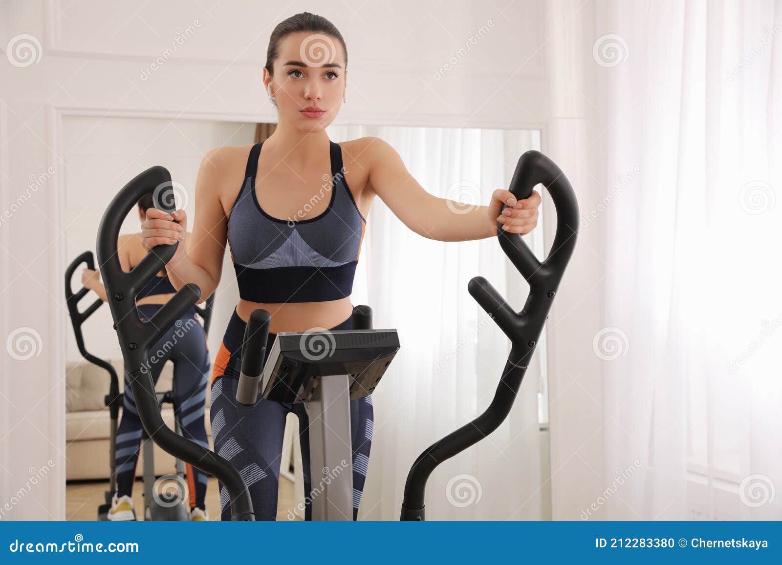 Woman Using Modern Elliptical Machine at Home Stock Photo - Image of ...