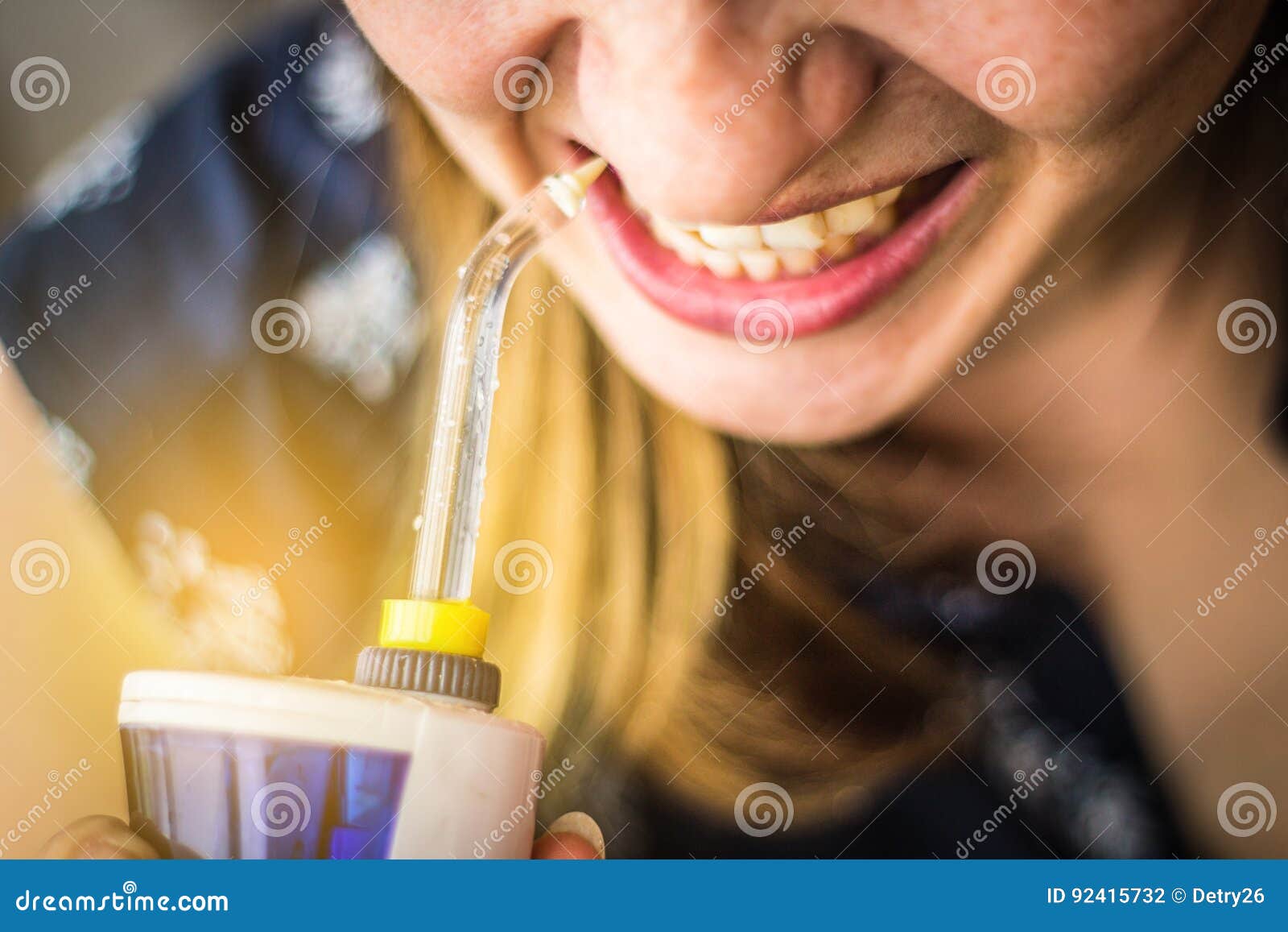 A Woman Using an Oral Irrigator in Bathroom. Selective Focus Stock ...