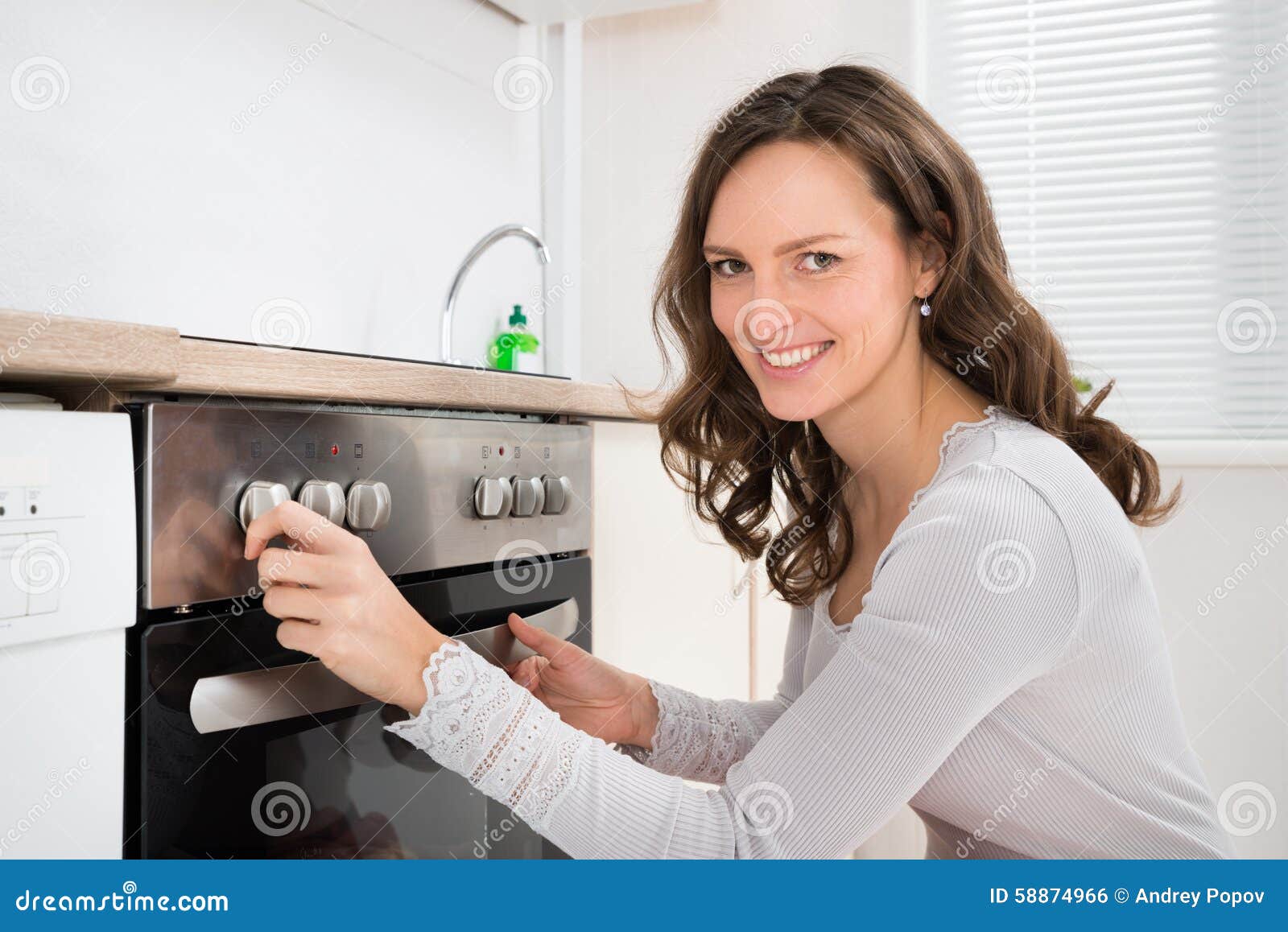 Woman Using Oven stock photo. Image of mode, indoors - 58874966
