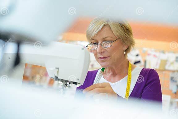 Woman Using Sewing Machine Framed through Another Sewing Machine Stock ...