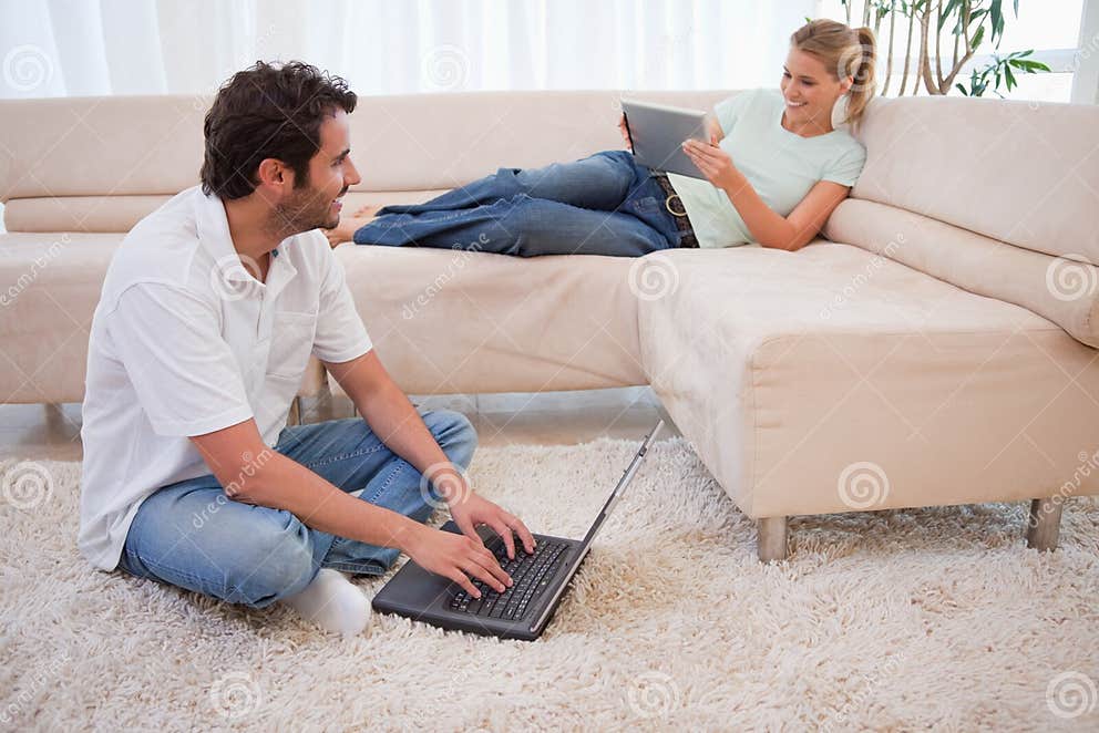 Woman Using a Tablet Computer while Her Fiance is Using a Laptop Stock ...