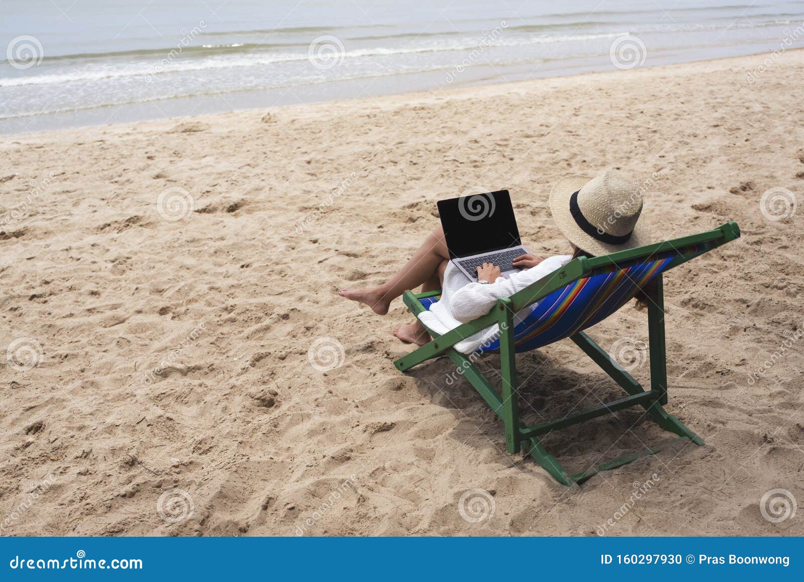 A Woman Using and Typing on Laptop Computer on a Beach Chair Stock ...