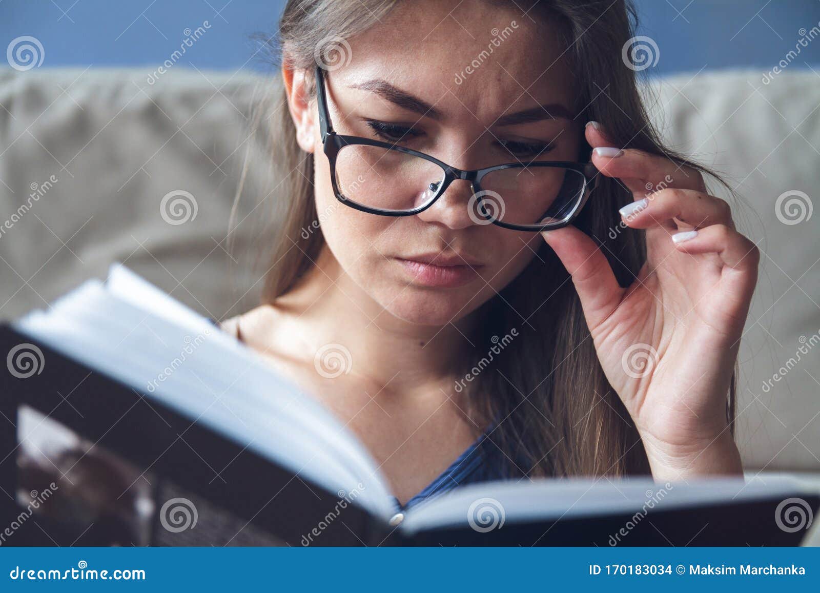 A Woman with Vision Problems is Reading a Book with Glasses Stock Photo ...