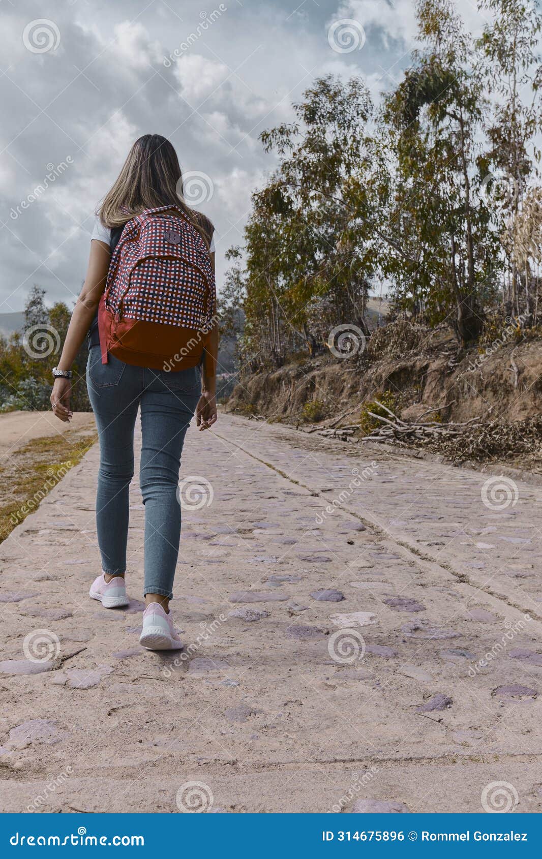 A Woman is Walking Down a Path with a Backpack on Her Back Stock Photo ...