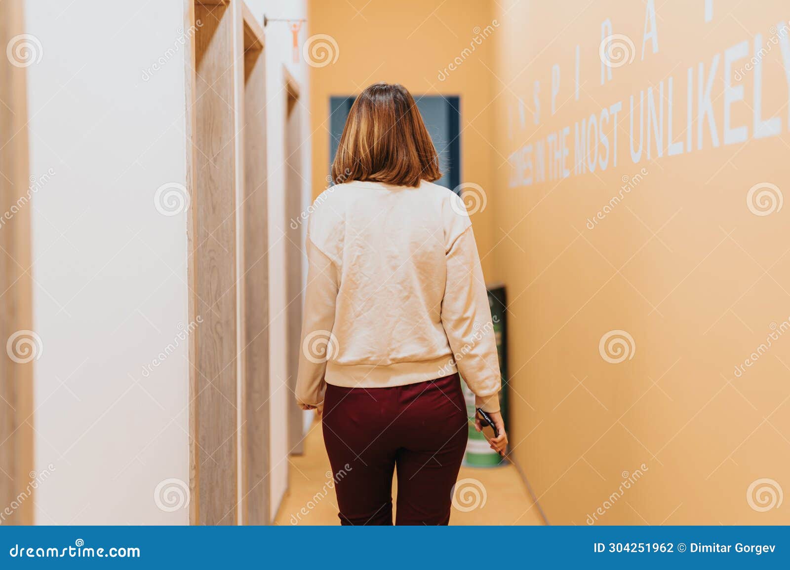 Woman Walking in a Orange Hall at the Office, she is Going To Restroom ...