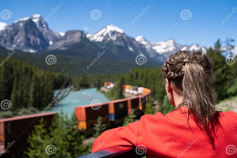 Woman Watches a Freight Train Pass by on the Morant`s Curve Viewpoint ... Woman Watches a Freight Train Pass by on the Morant`s Curve Viewpoint ...
