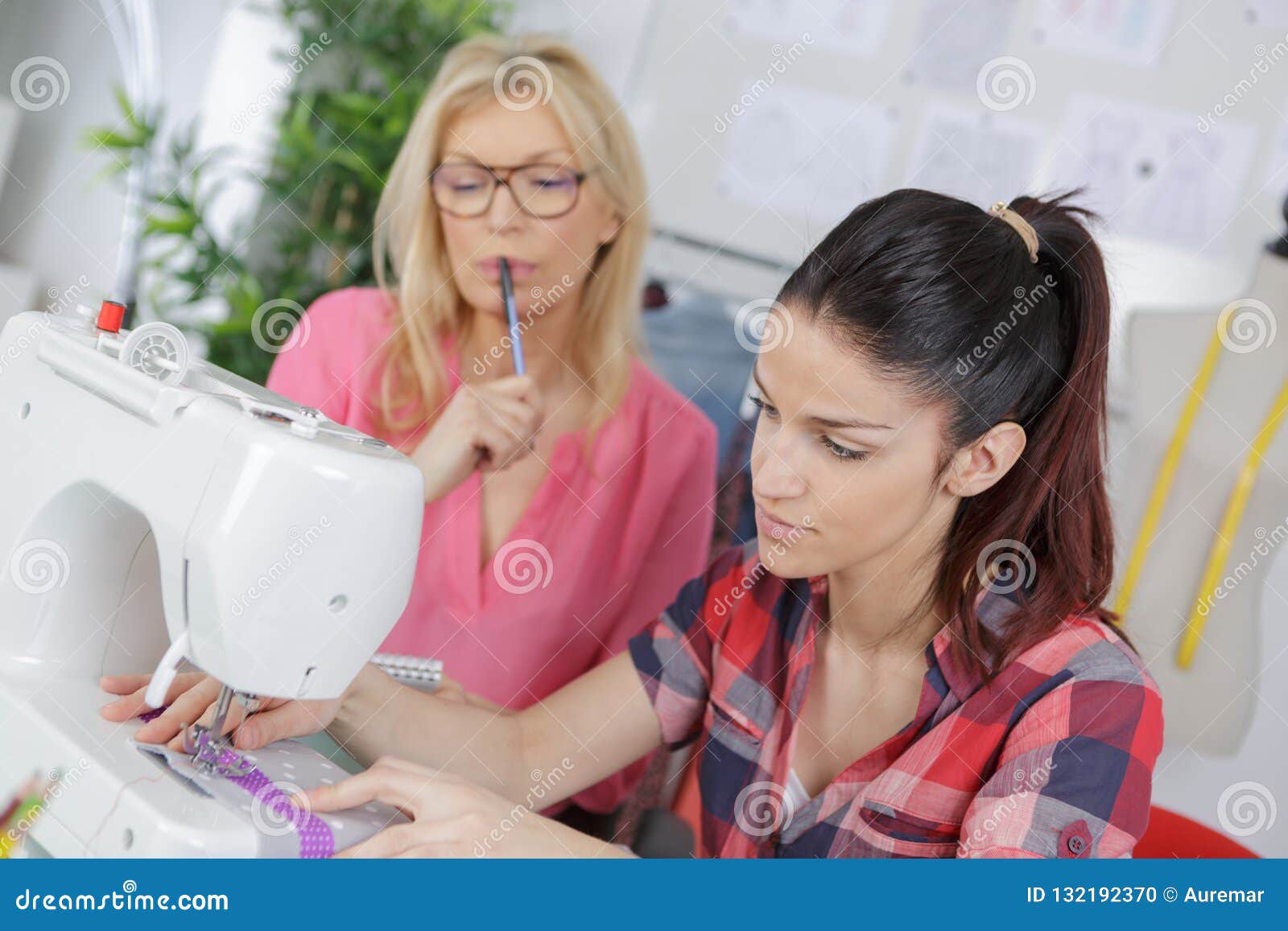 Woman Watching Younger Lady Use Sewing Machine Stock Photo - Image of ...