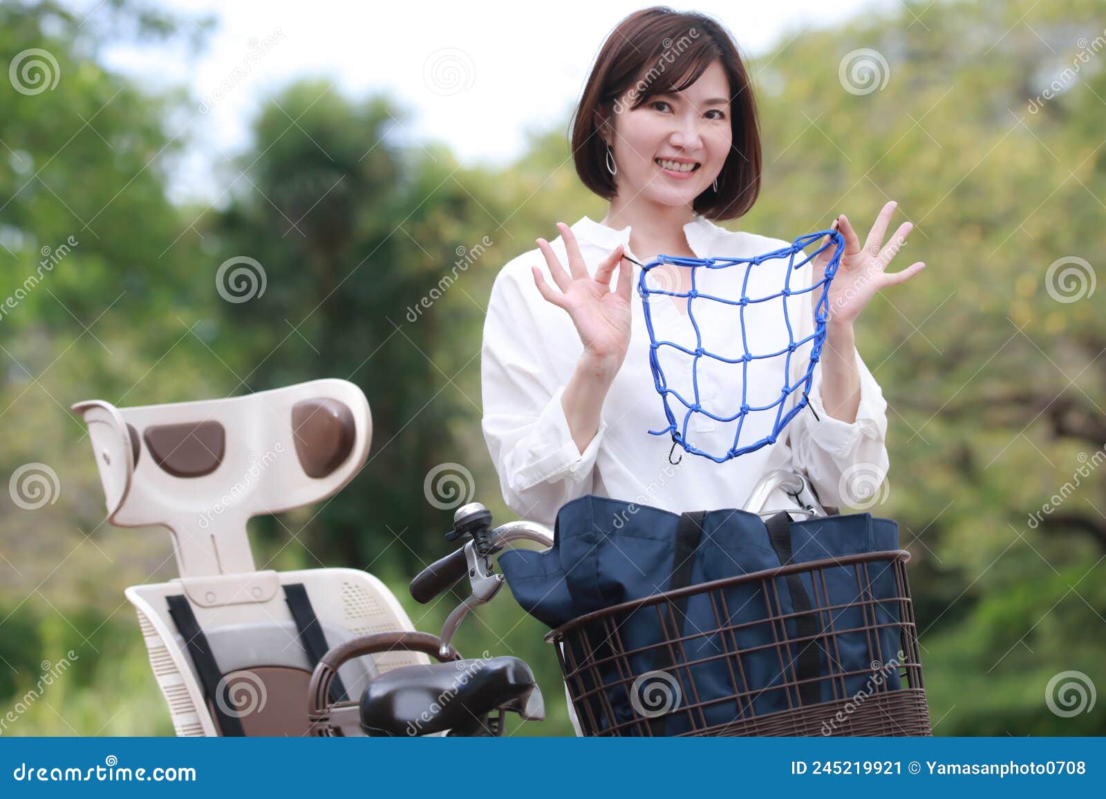 A Woman Wearing a Bicycle Net in the Front Basket of a Bicycle Stock ...