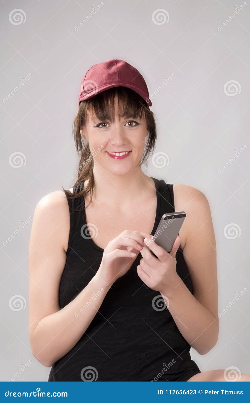 Woman Wearing a Cap Using a Mobile Phone Stock Image - Image of female ...