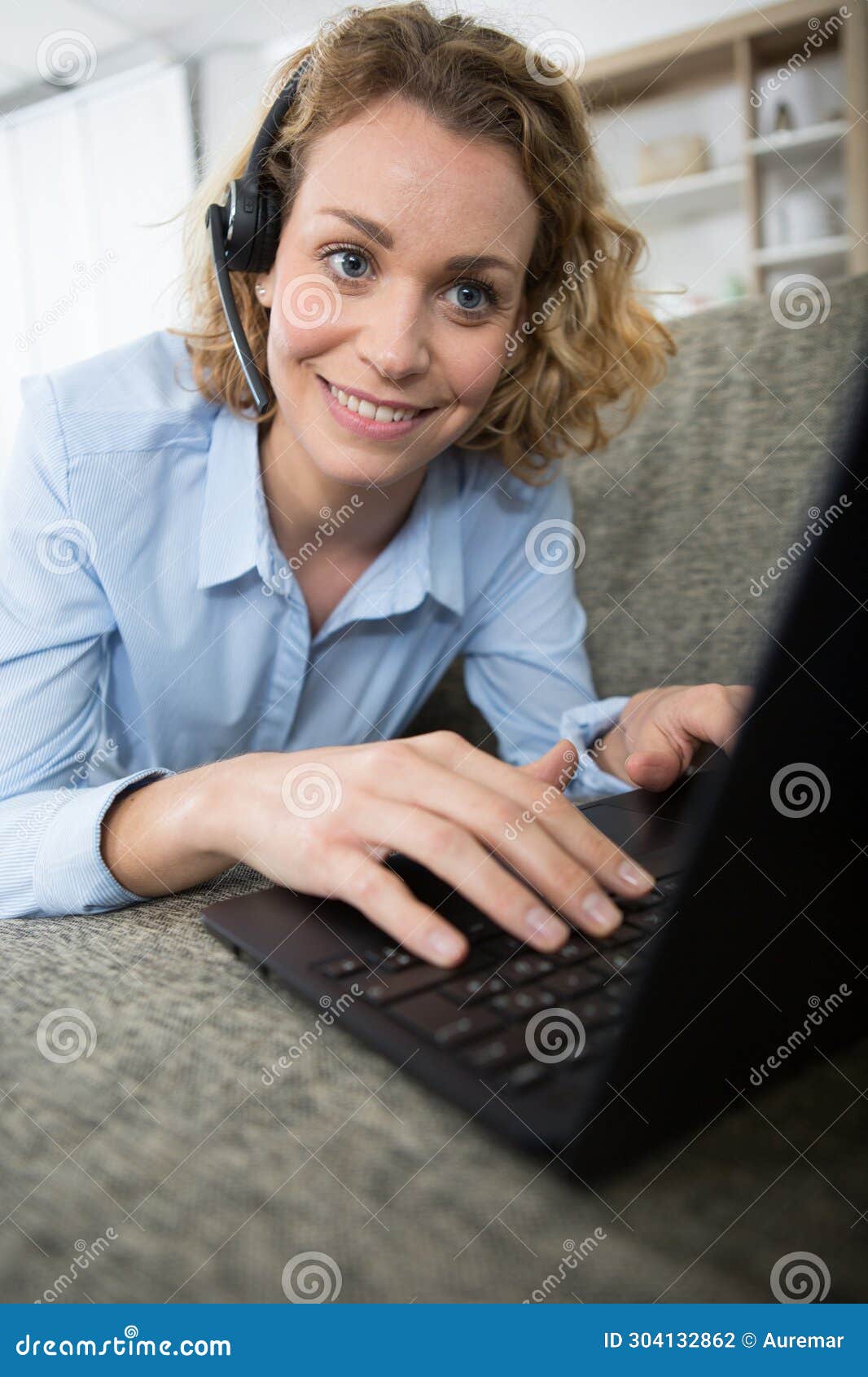 Woman Wearing Headset and Using Laptop on Sofa Stock Photo - Image of ...
