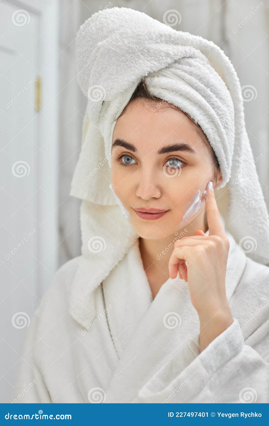 Woman In White Bathrobes Applying Apply Facial Cream Stock Image