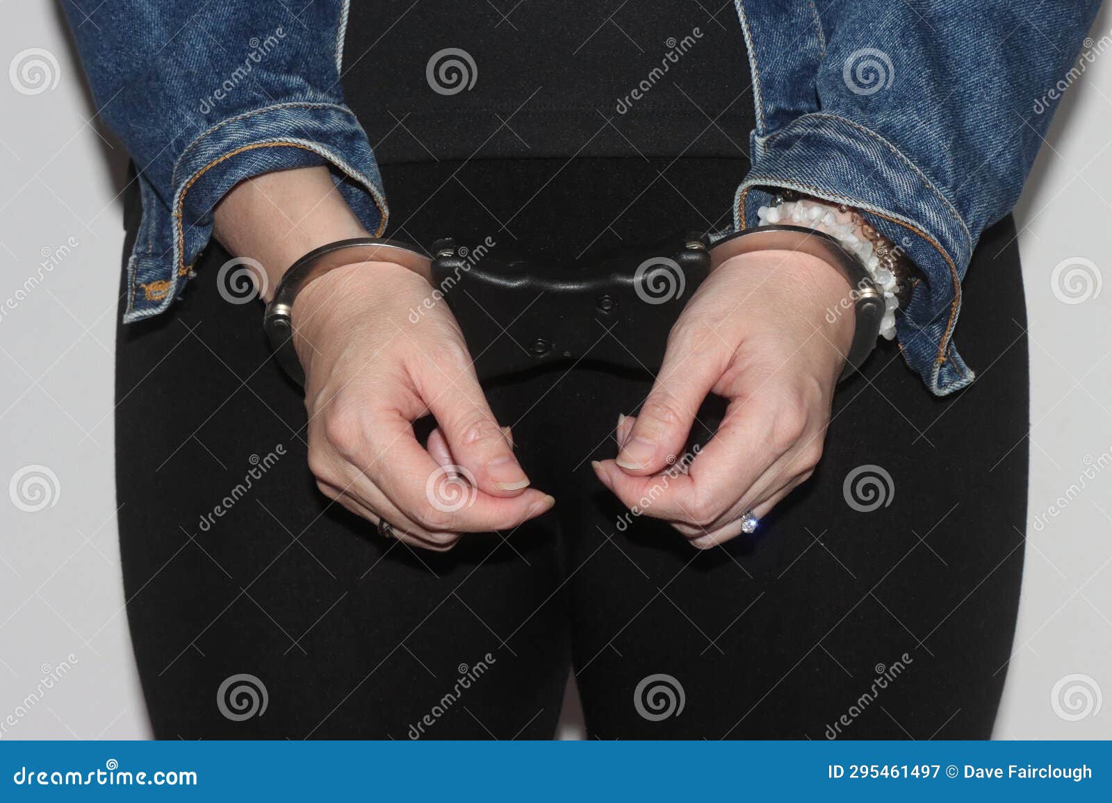 A Woman Who Has Been Arrested And Has Her Hands Handcuffed As She