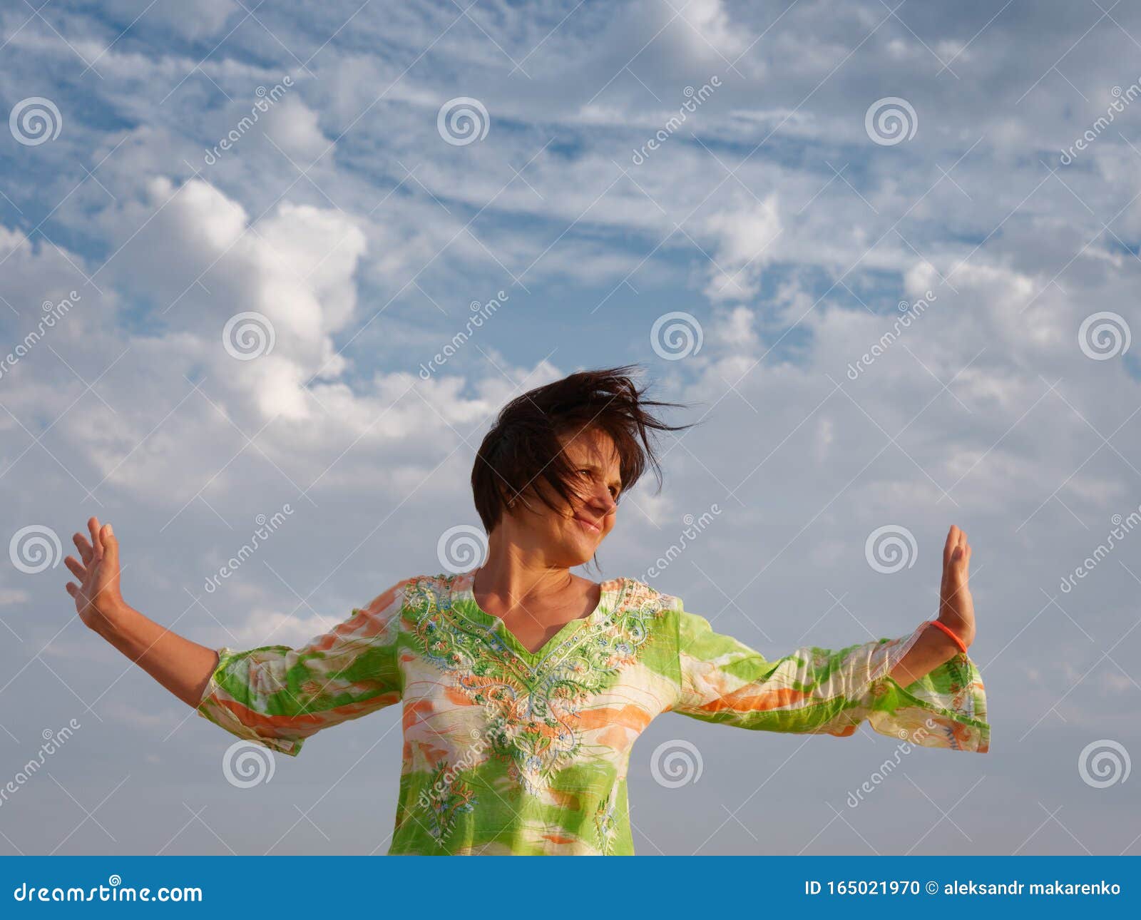 Woman in the Wind Against a Blue Sky with Clouds Stock Photo - Image of ...