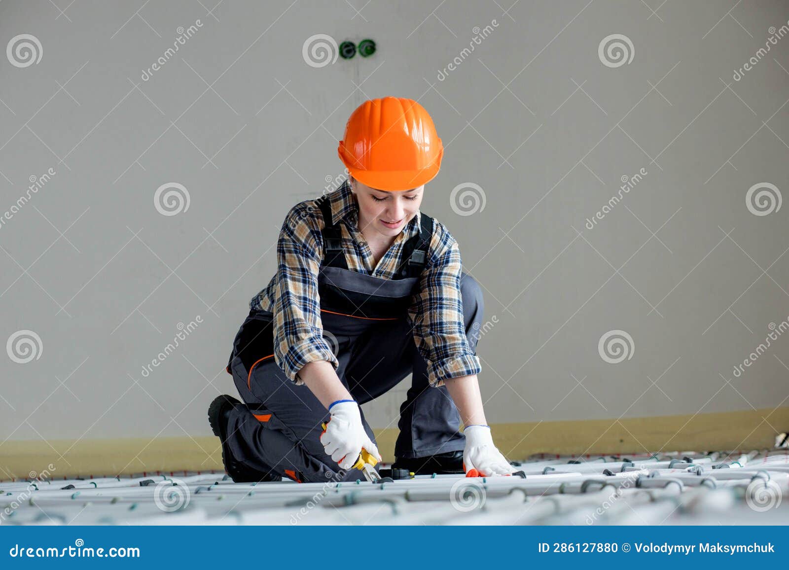 Woman Worker is Installing Underfloor Heating System. Warm Floor ...