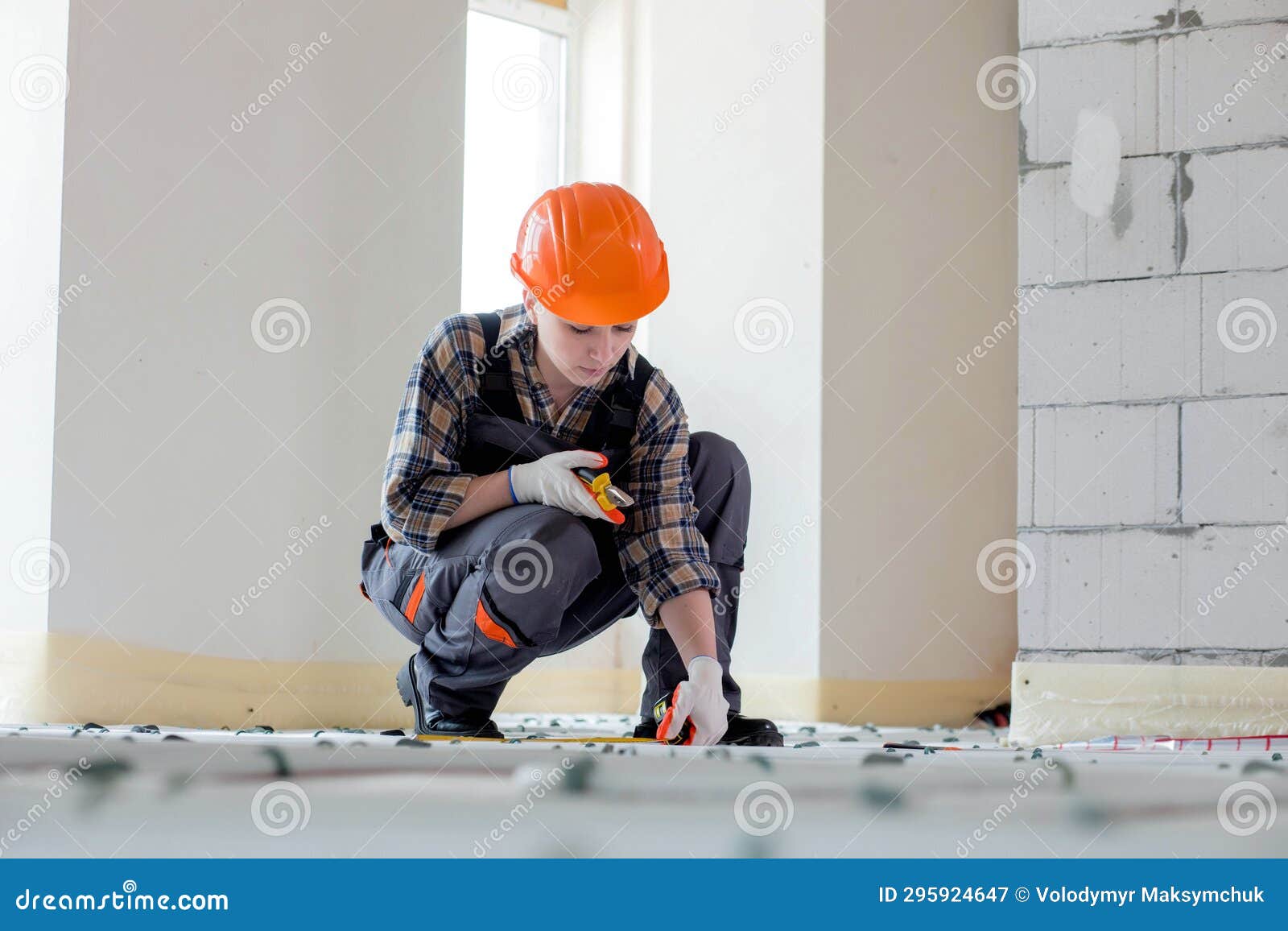 Woman Worker is Installing Underfloor Heating System. Warm Floor ...