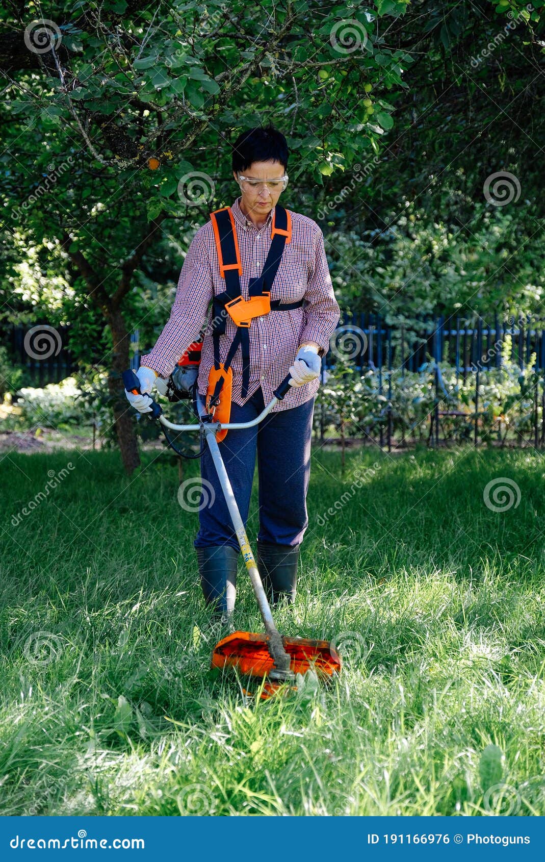 Woman Worker Mowing the Grass in Garden Using String Trimmer Stock ...