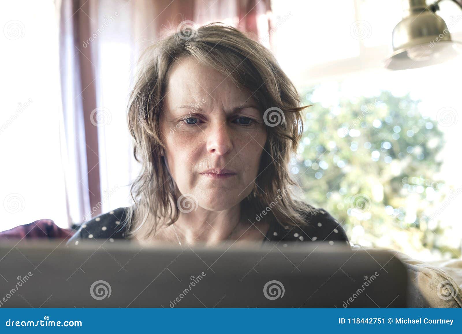 Woman Working on Computer at Home with Window Behind Her Stock Image ...
