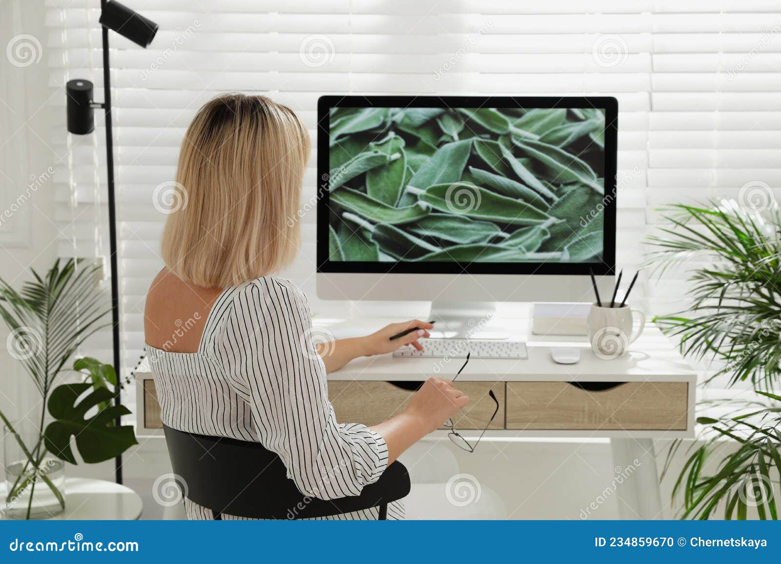 Woman Working on Computer at Table in Room, Back View. Interior Design ...